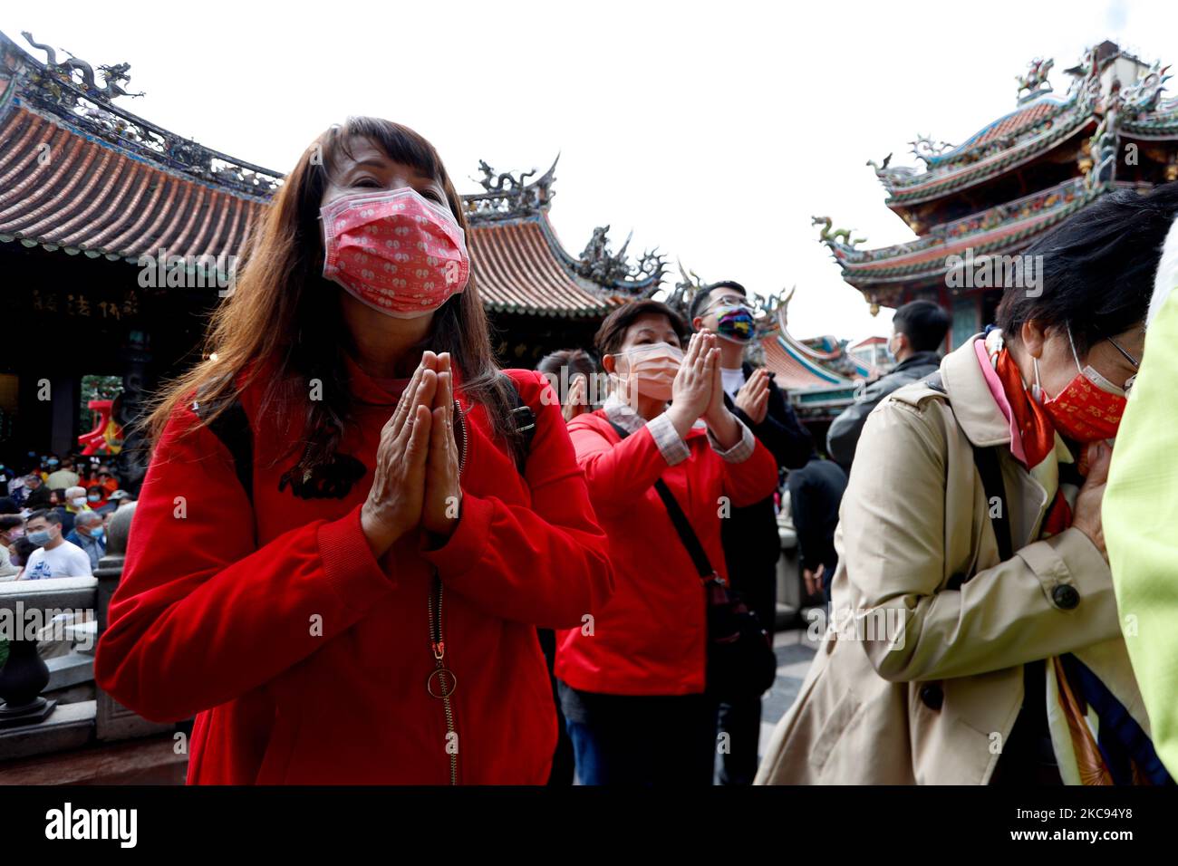 Taiwanese people wearing a face mask pay worships at Lungshan Temple ...
