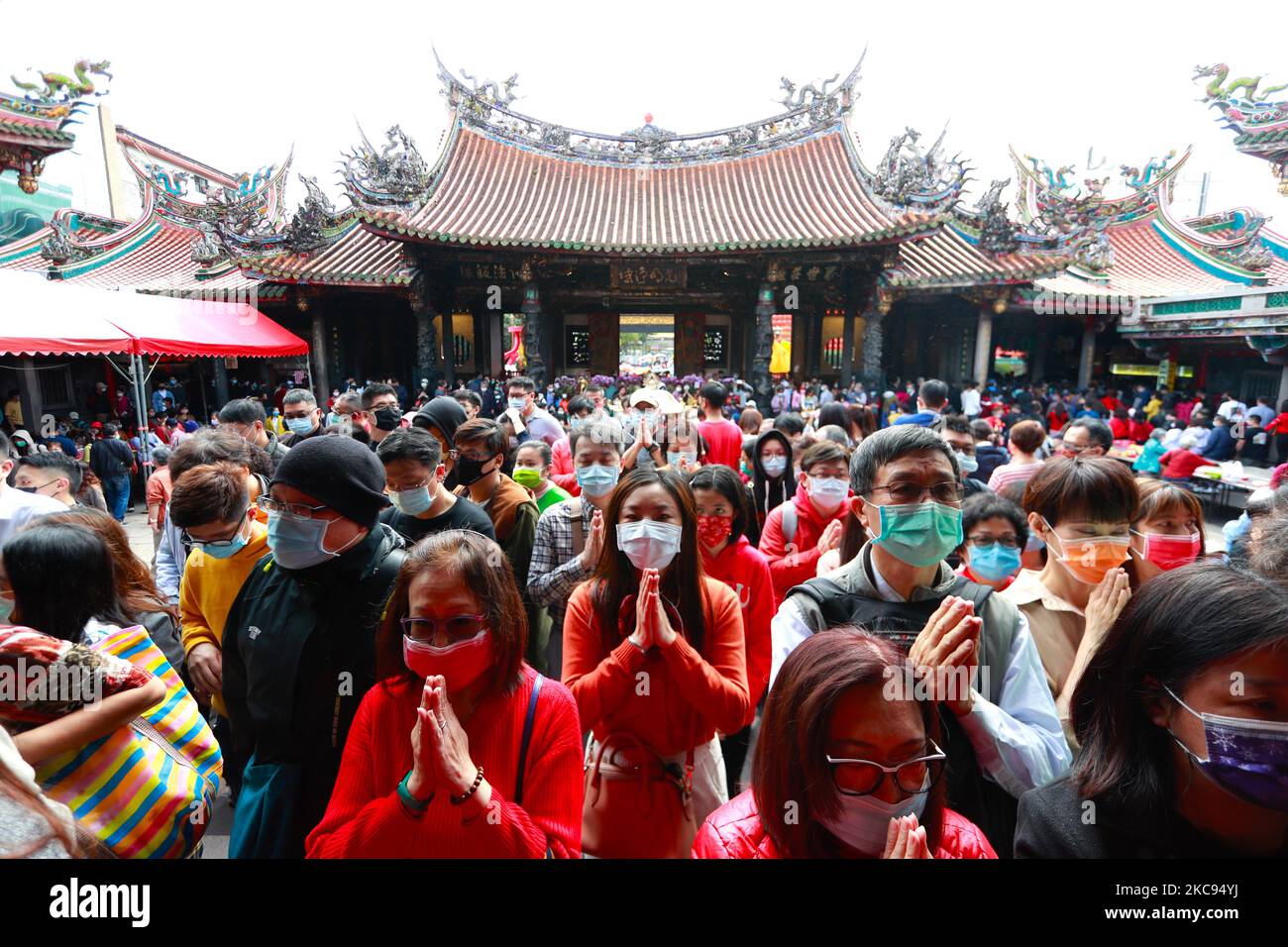 Taiwanese people wearing a face mask pay worships at Lungshan Temple ...