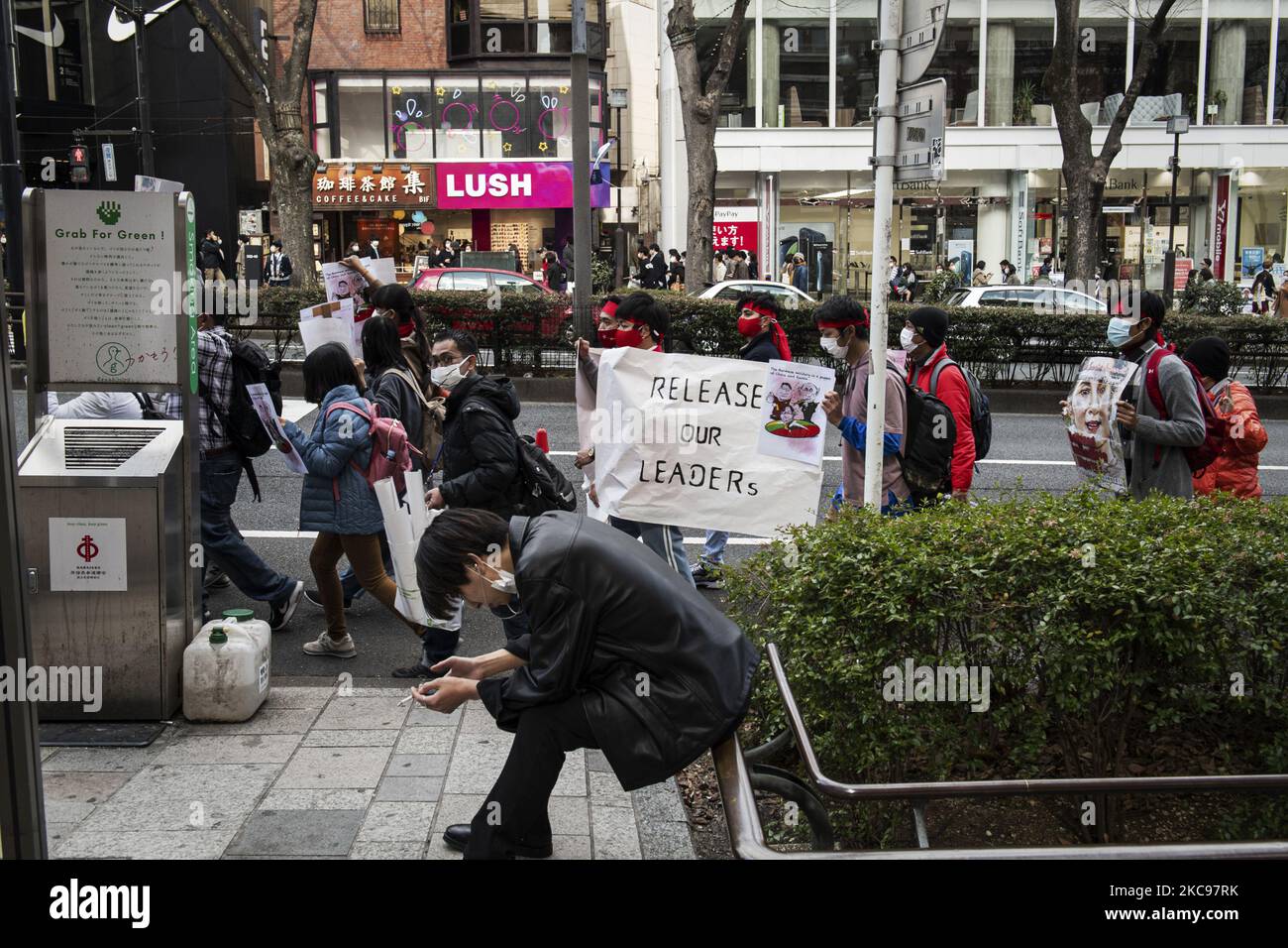 Participates holding placards and pictures pass by a smoking place at ...