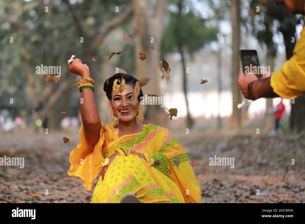 A girl throw up leaves as she celebrates spring festival on the first ...