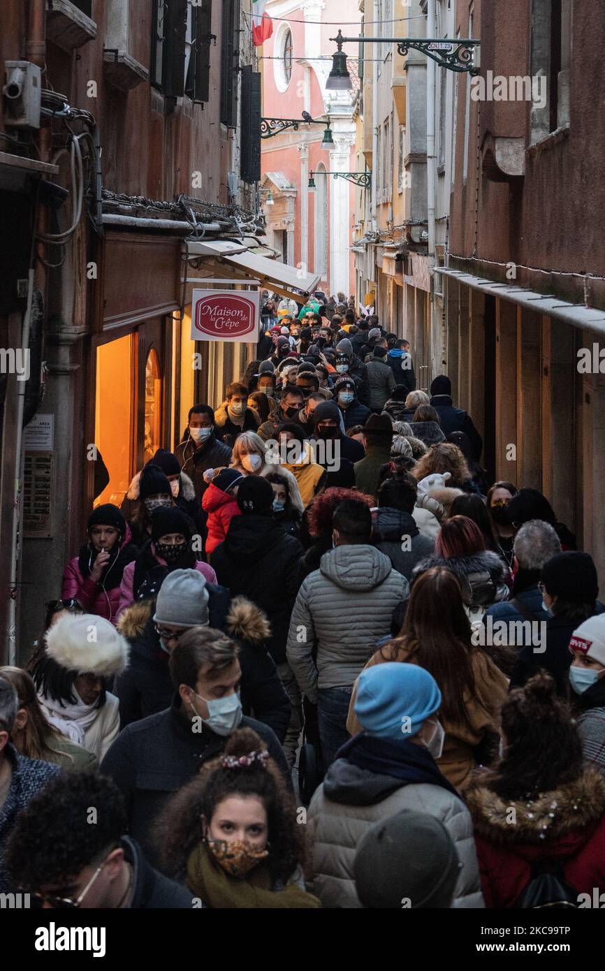 A crowded street in Venice with people walking not respecting the rules ...