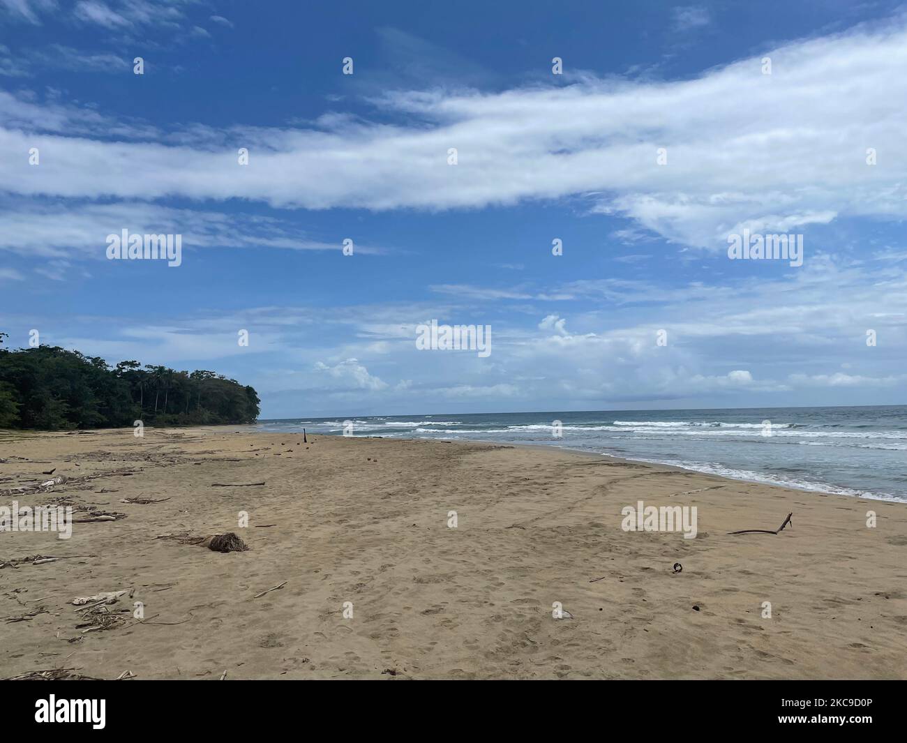 A sandy beach shore against the blue sky with floating clouds in Punta ...