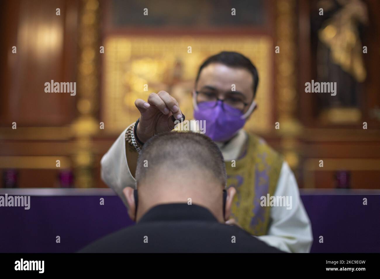 Father Hugo provides ash to a person's head as part of the Ash ...