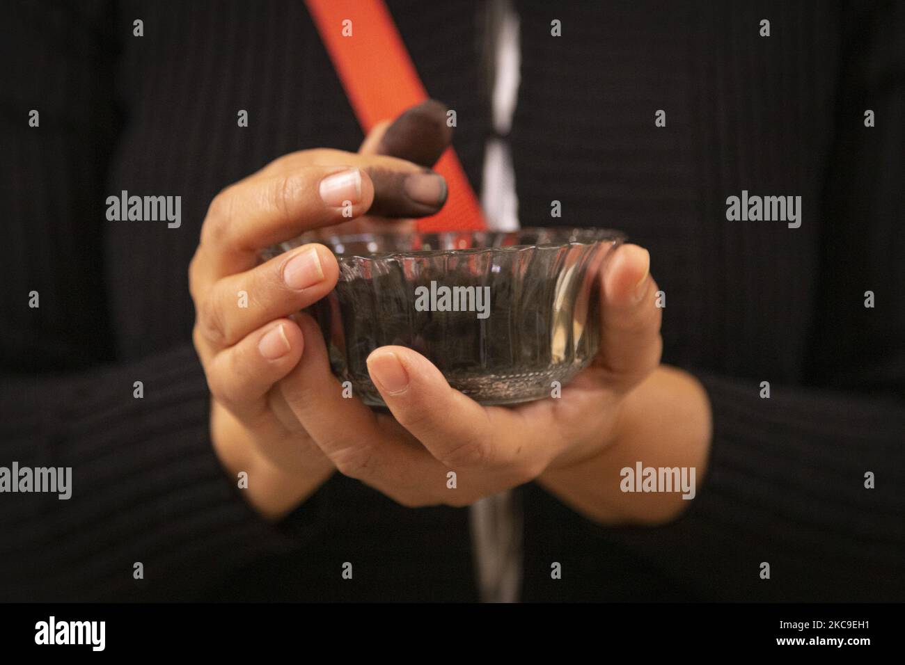 Detail of the hands of a church worker with ash as part of the Ash ...