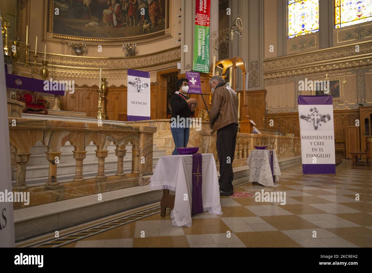 A church worker provides ash to a person's head as part of the Ash ...