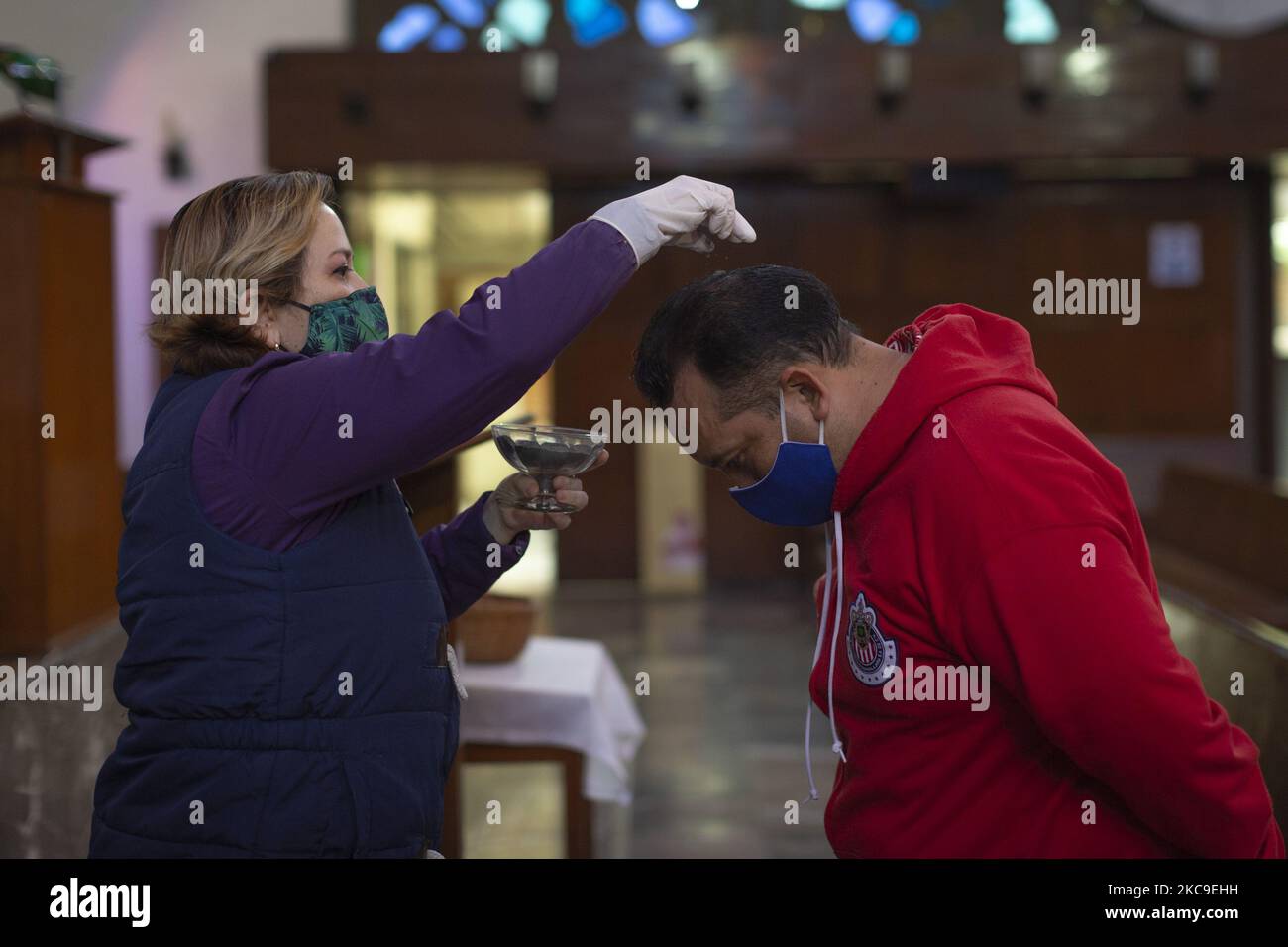 A church worker provides ash to a person's head as part of the Ash ...