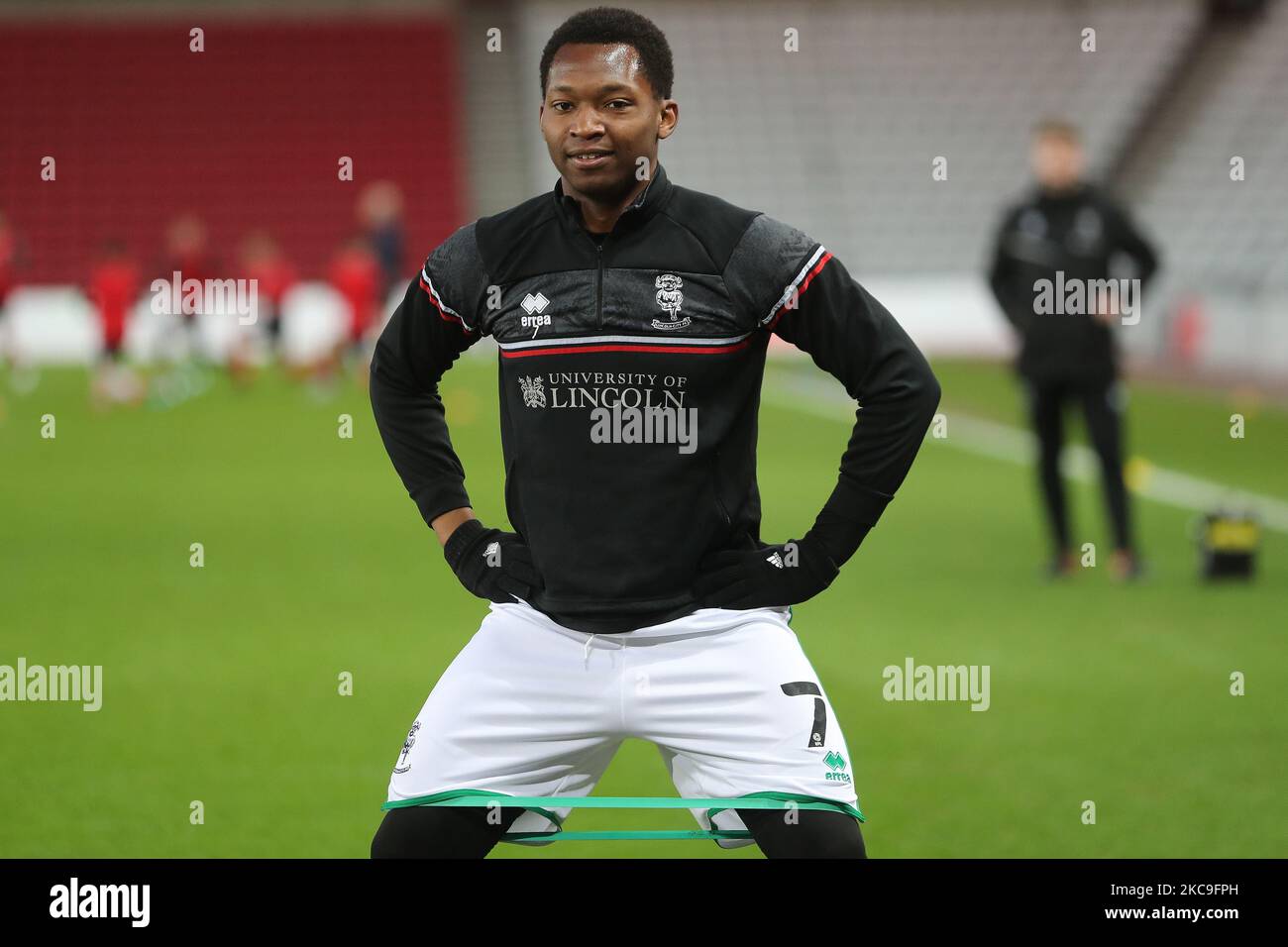 Tayo Edun of Lincoln City warms up prior to the EFL Trophy match ...