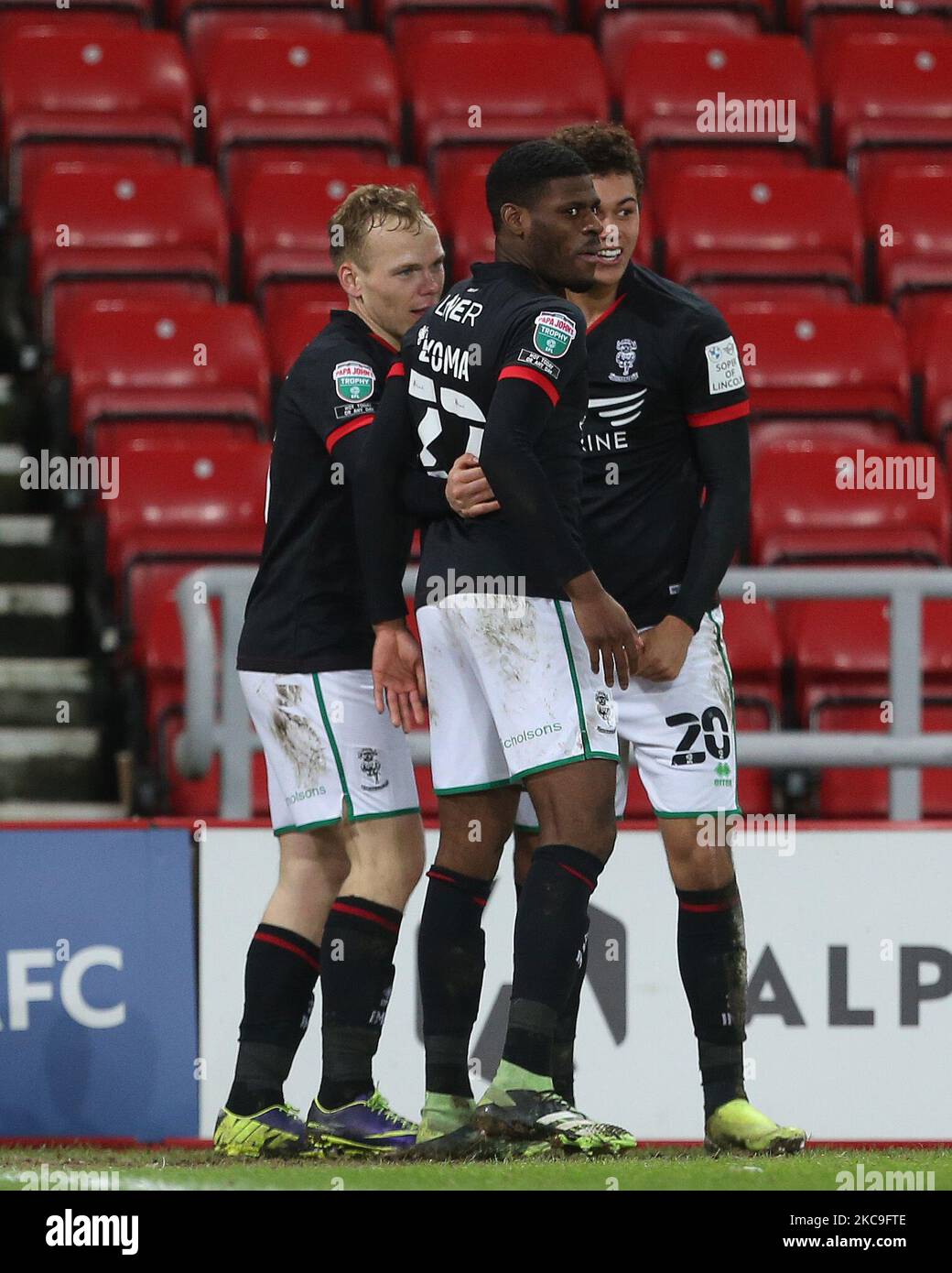 Lincoln City's Anthony Scully celebrates with Timothy Eyoma and Brennan ...