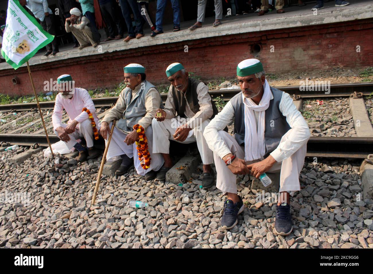 Farmers sit on a railway track to stop train services as a part of ...