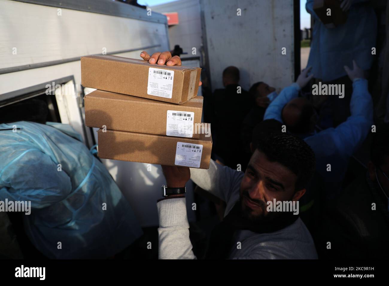 Workers unload from a truck, boxes of Russian-made Sputnik V vaccine ...