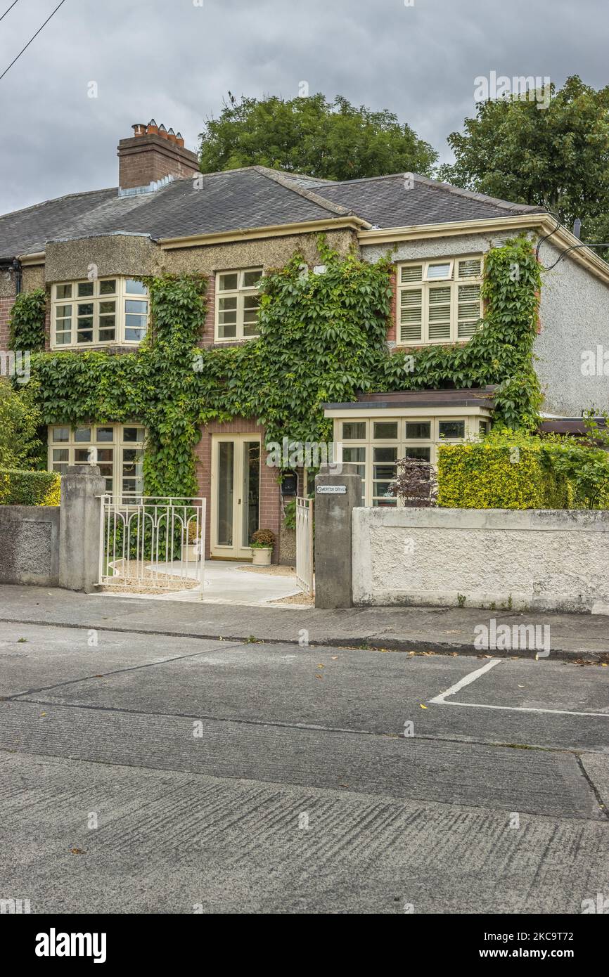 A vertical of a beautiful house covered with climbing plants in ...