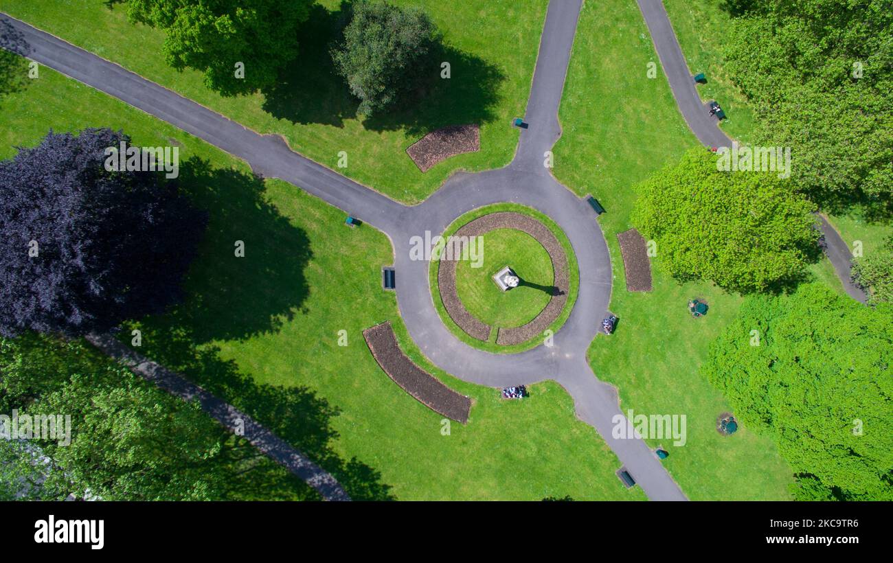 An aerial top view of a green park with pathways near green trees on a ...