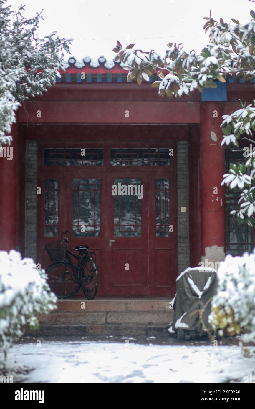 A vertical shot of a traditional Chinese entrance with red doors and a ...