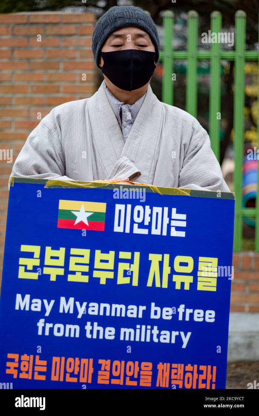 A South Korean monk in Jogyesa Temple holds a placard during a protest ...