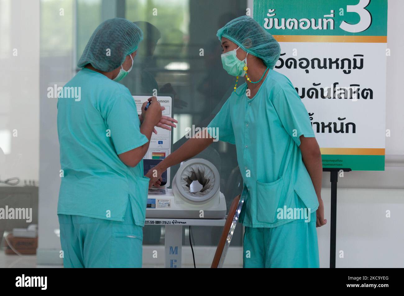 Health workers wearing an operation suite with a surgical mask stand in ...