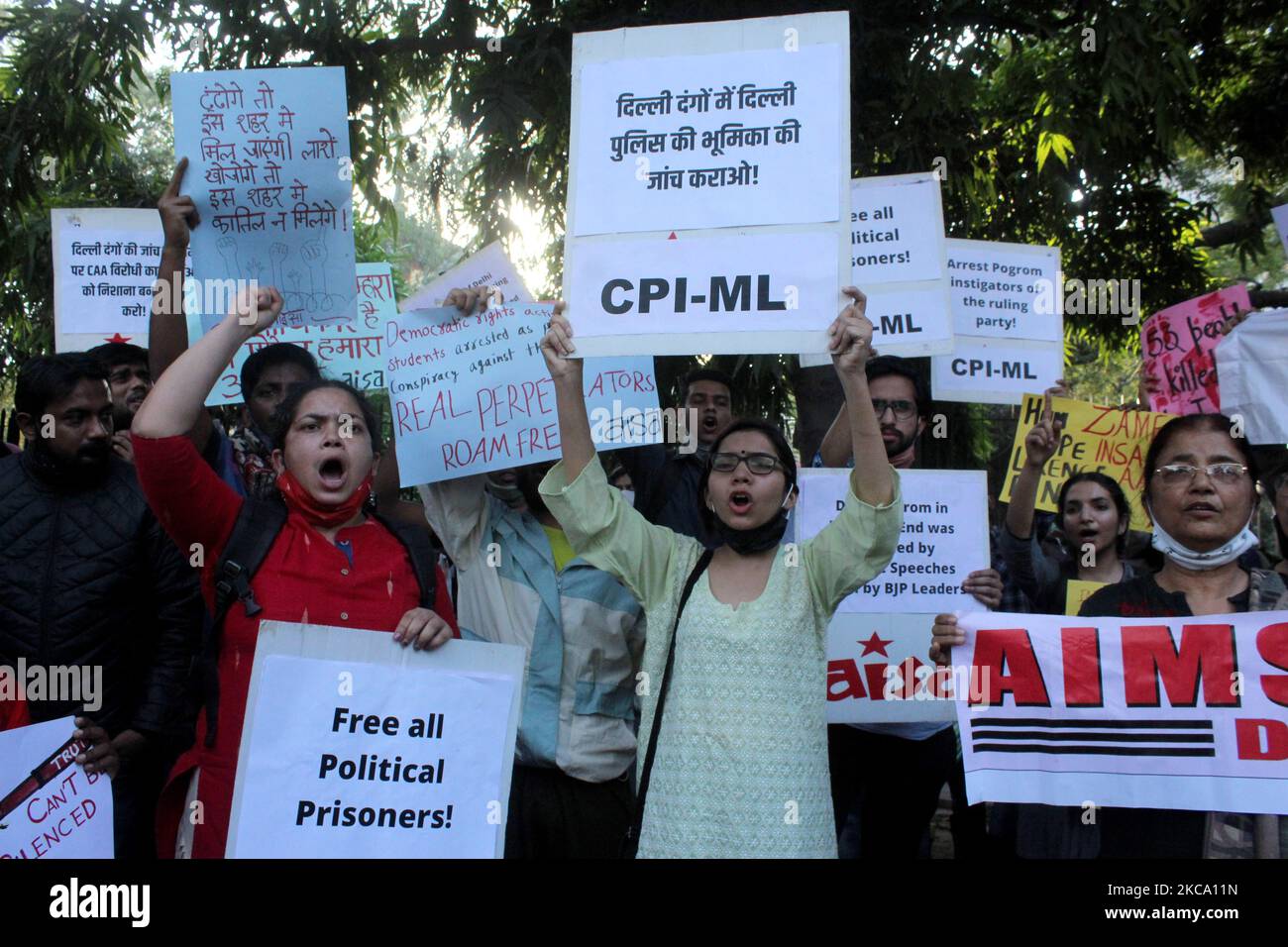 Demonstrators hold placards as they shout slogans during a protest ...