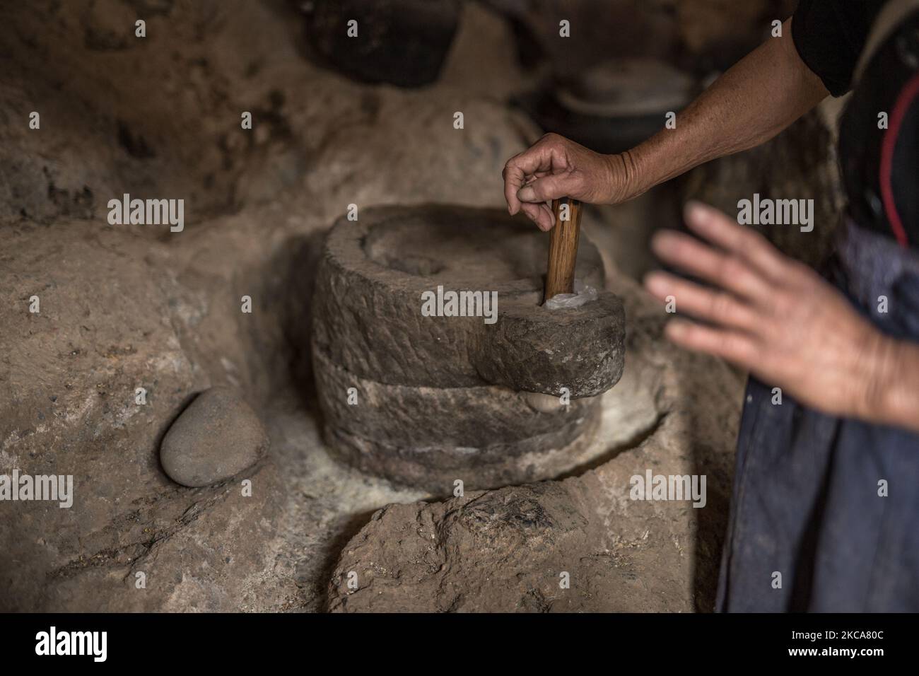 A female grinding grain in a stone mill Stock Photo - Alamy