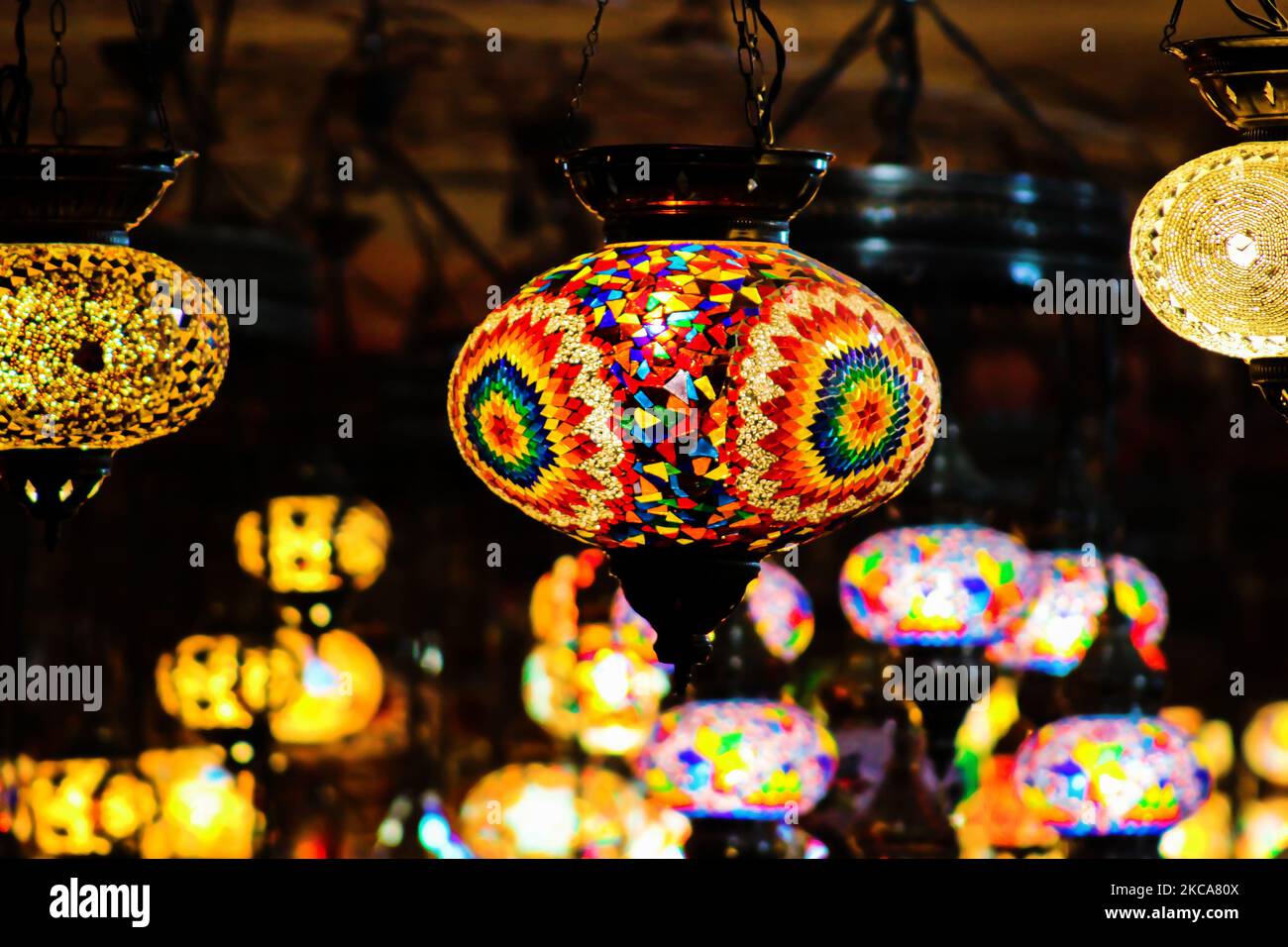 A colorful medieval Arabic lamp hanging from a ceiling in a blurred ...
