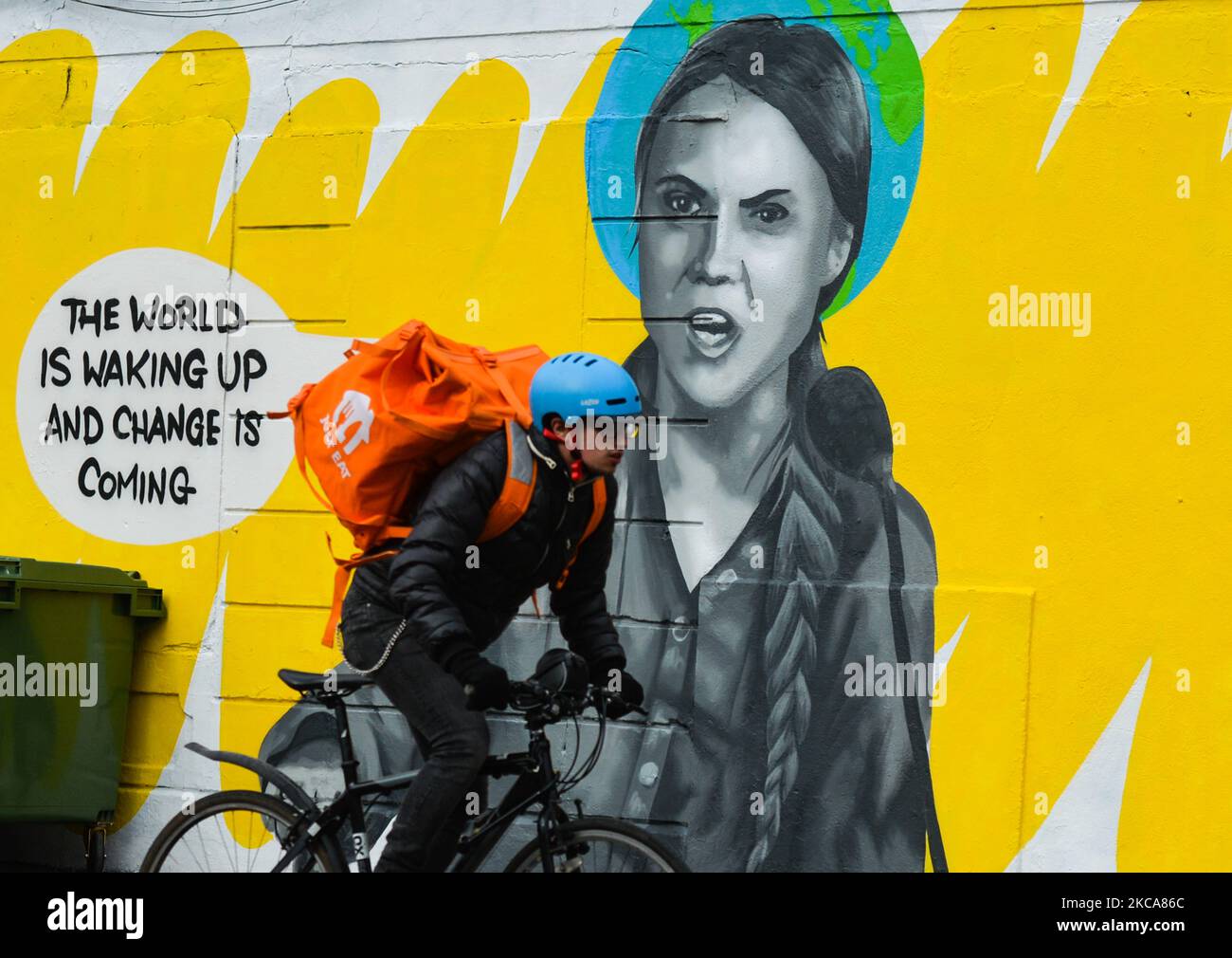 A 'Just Eat' courier cycles by a new mural by the Irish artist Emmalene ...