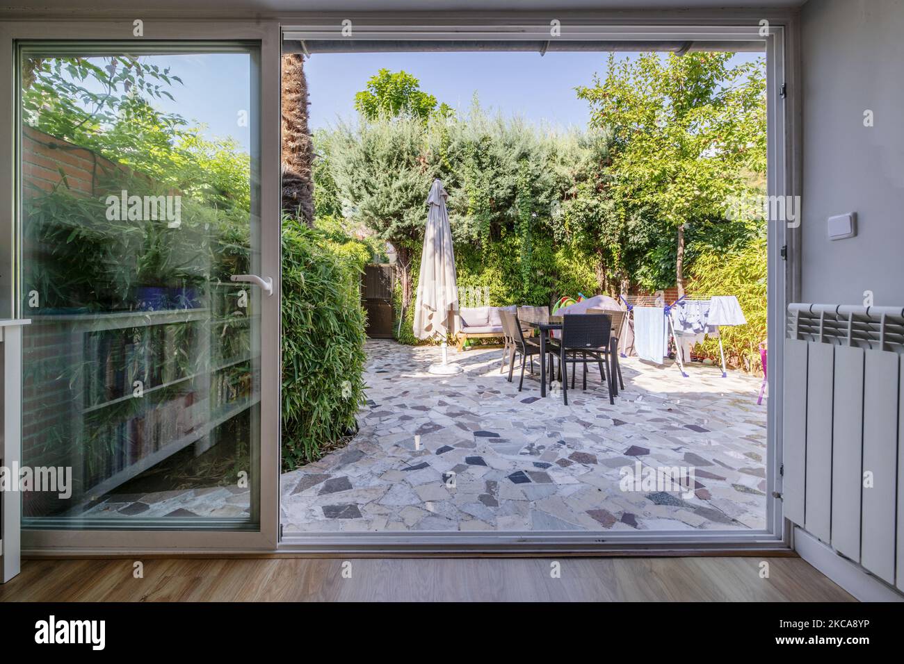 Large white aluminum and glass window open in a living room to give ...