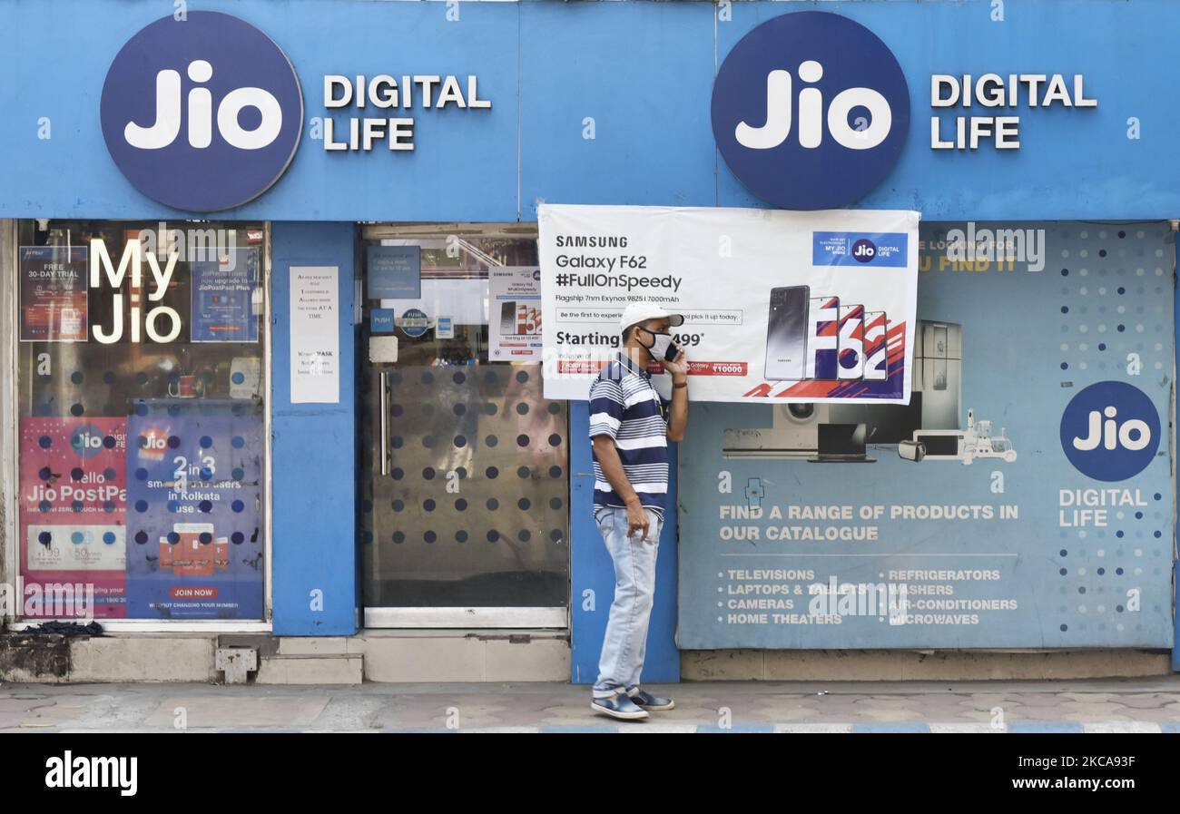 A man talks on his phone in front of a Reliance Jio store in Kolkata ...