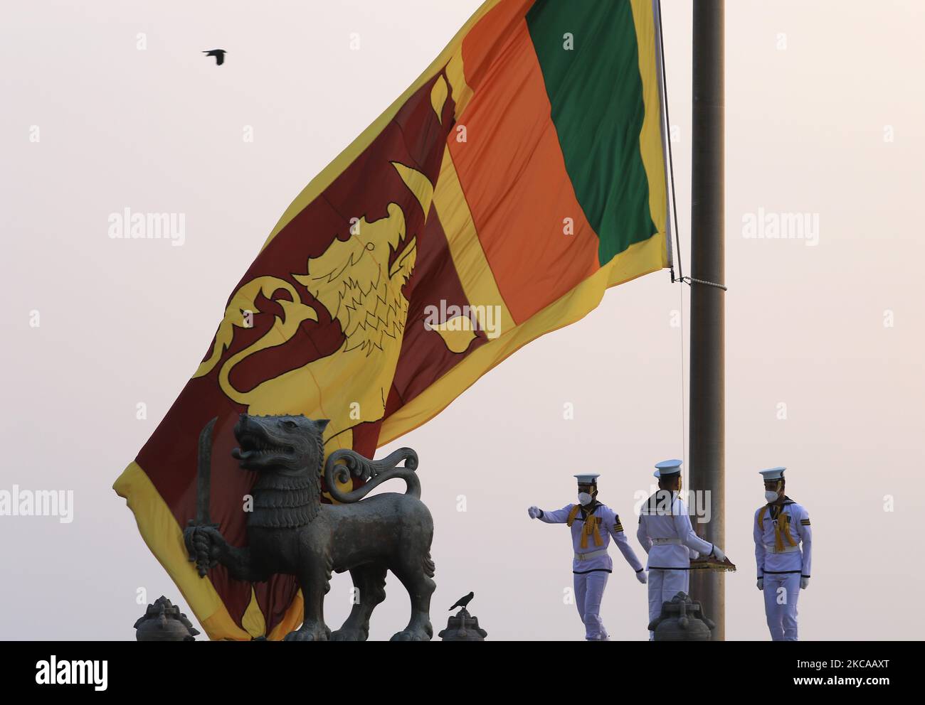 Sri Lankan Navy solders wearing protective masks lower the national ...