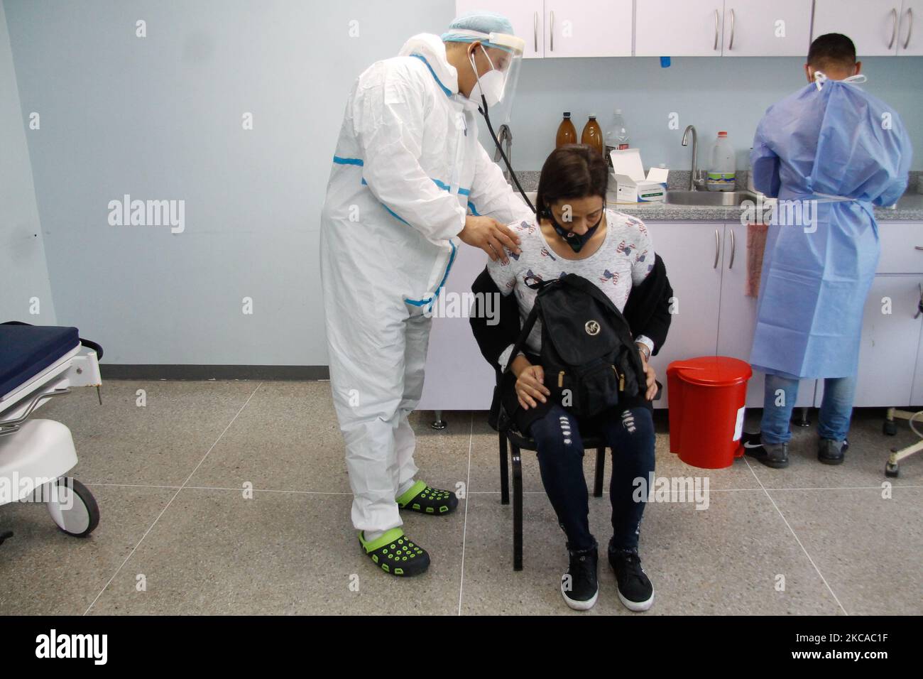 A healthcare worker checks a patient with Covid-19 related symptoms ...