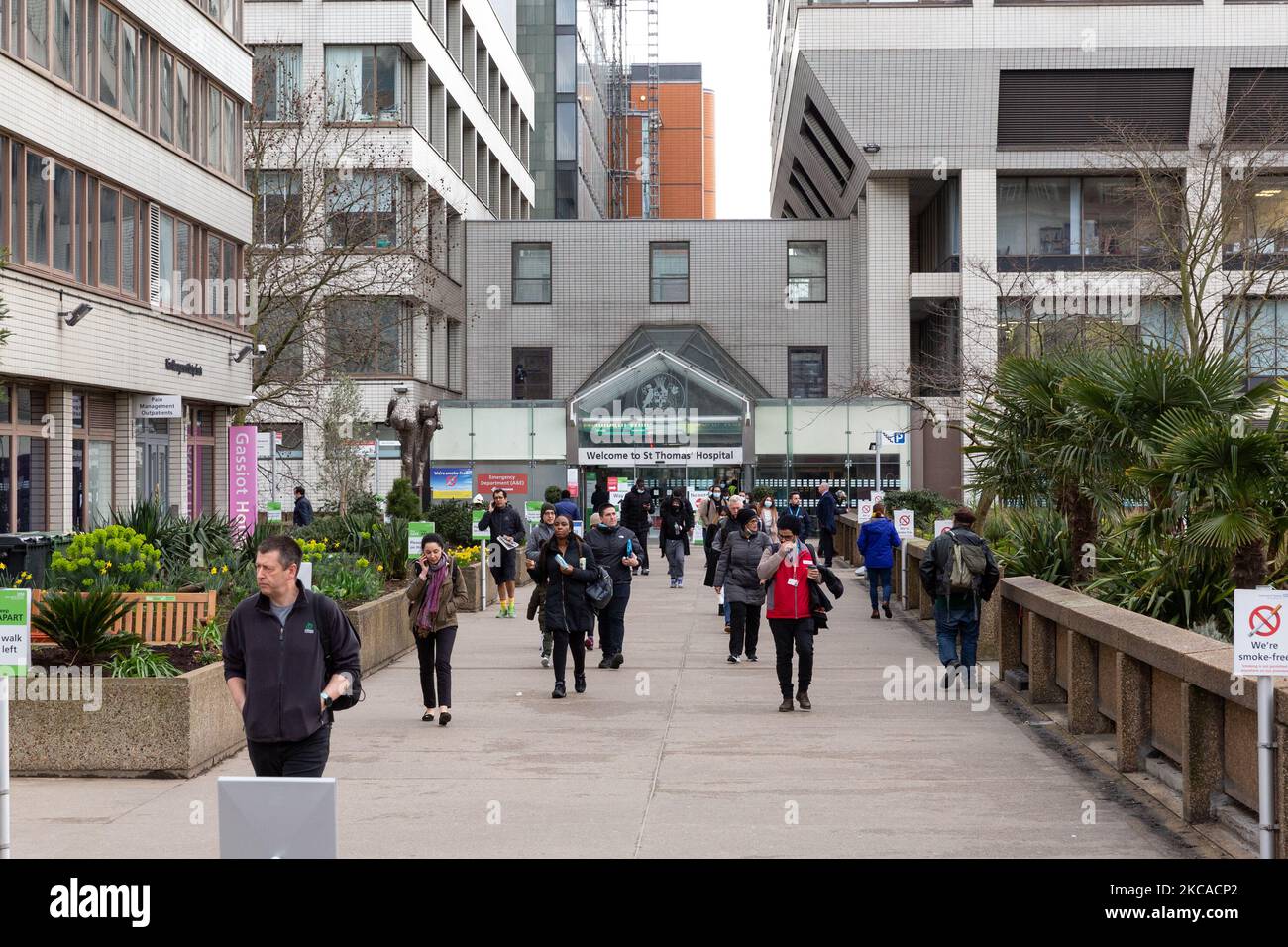 Patients and NHS staff walk in front of St Thomas Hospital located in ...