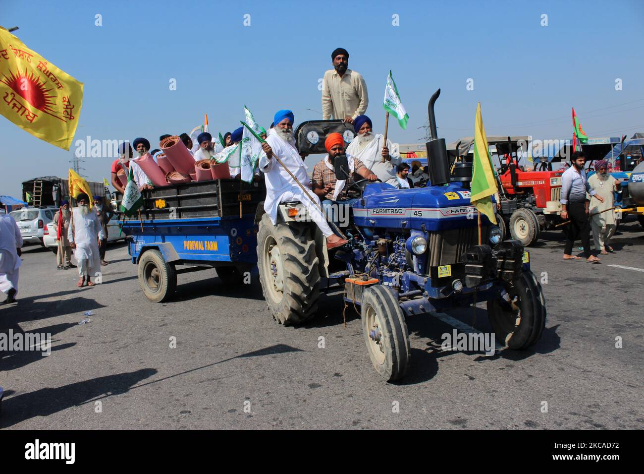 Farmers arrive on a tractor to take part in a protest by blocking KMP ...