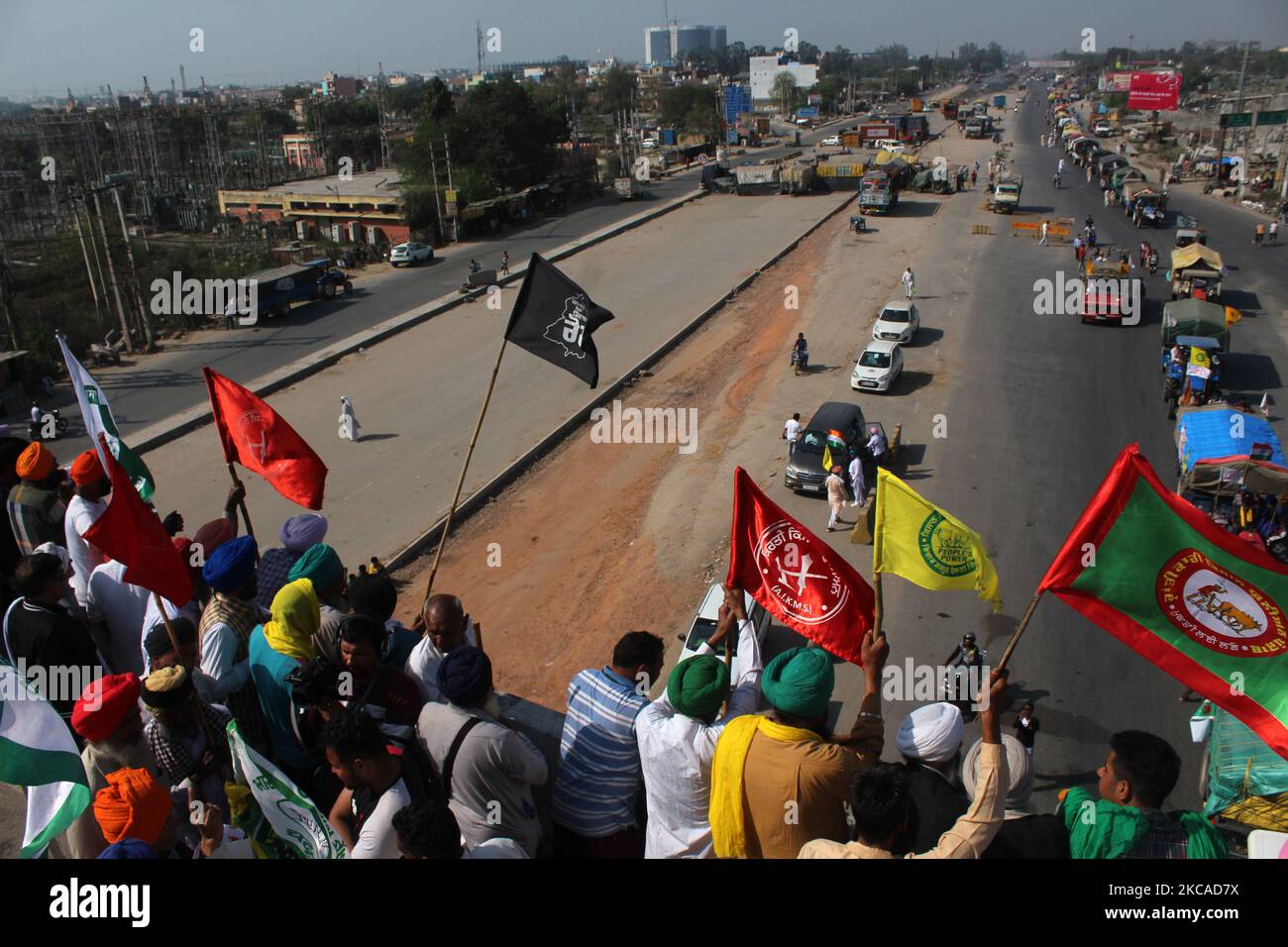 Farmers waving flags cheer as more tractor trollies arrive to take part ...