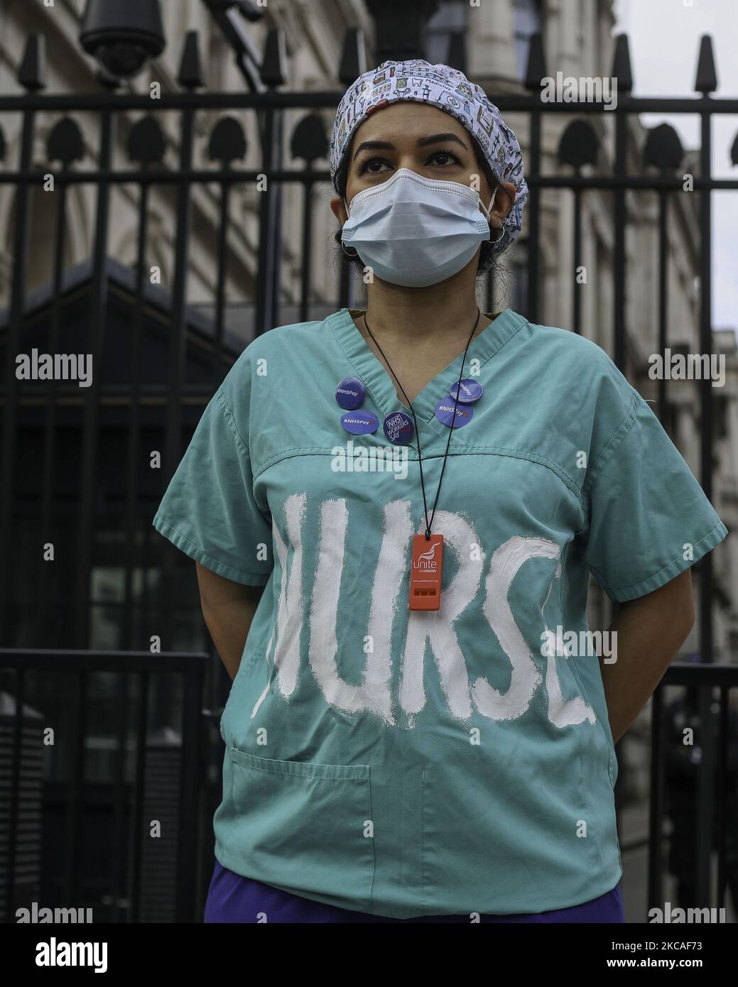 Nurse holds a sign outside of Downing Street, Nurses are threatening to ...
