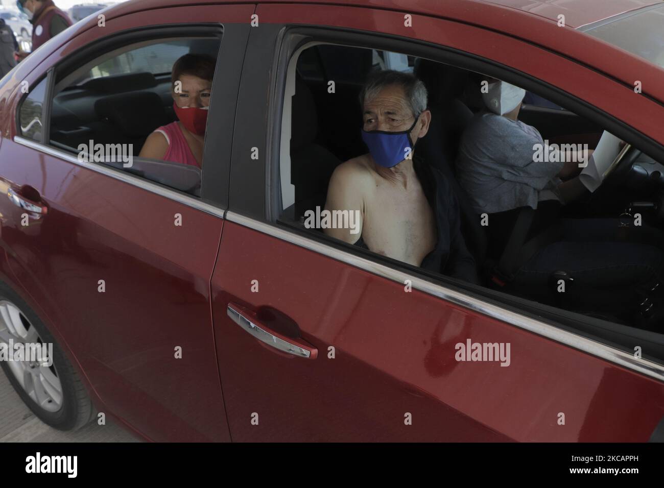 Older adults accompanied by their family members, attend by car before ...