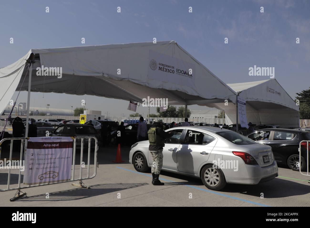 Older adults accompanied by their family members, attend by car before ...