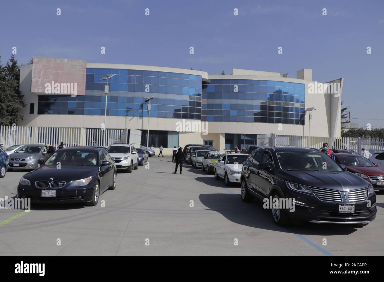 Older adults accompanied by their family members, attend by car before ...
