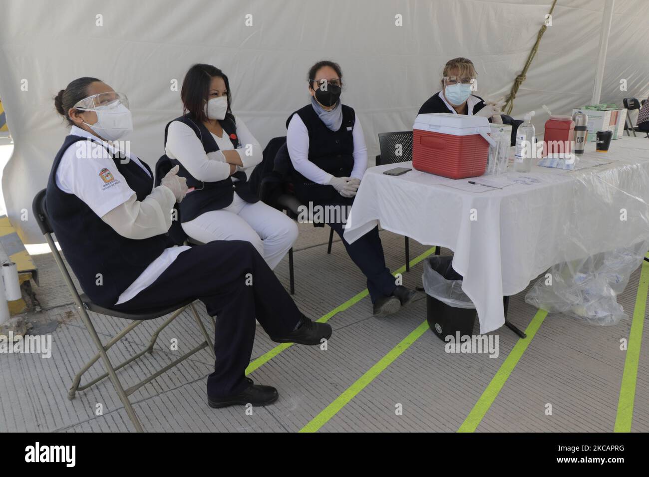 Medical personnel wait for older adults to be immunized with the Pfizer ...
