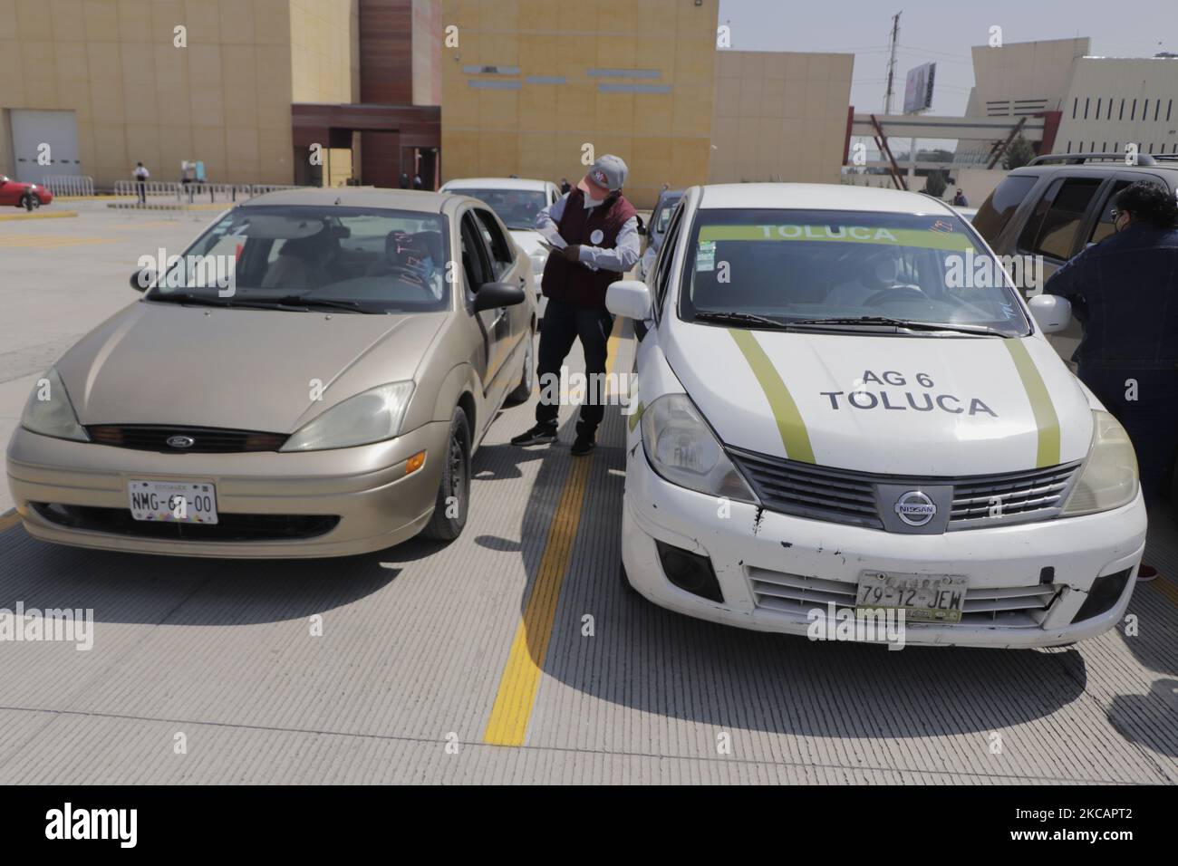 Older adults accompanied by their family members, attend by car before ...