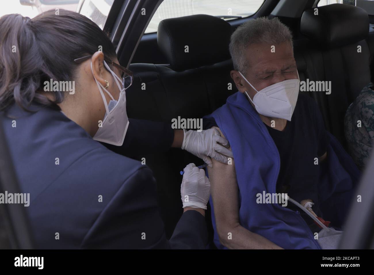 A senior citizen is immunized with the Pfizer BioNTech vaccine against ...