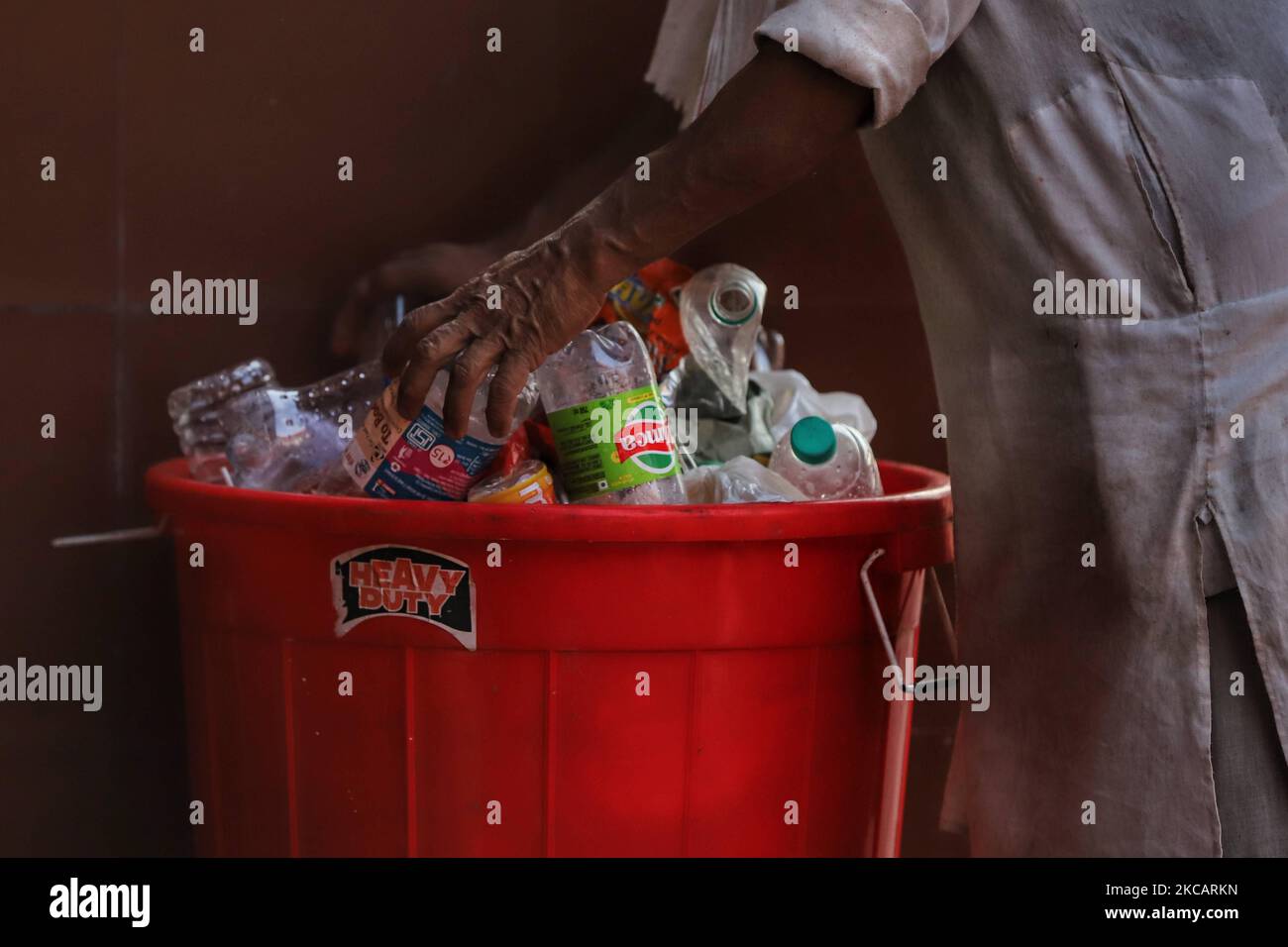 A man collects plastic bottles in a Trash can at Jama Masjid in Old ...