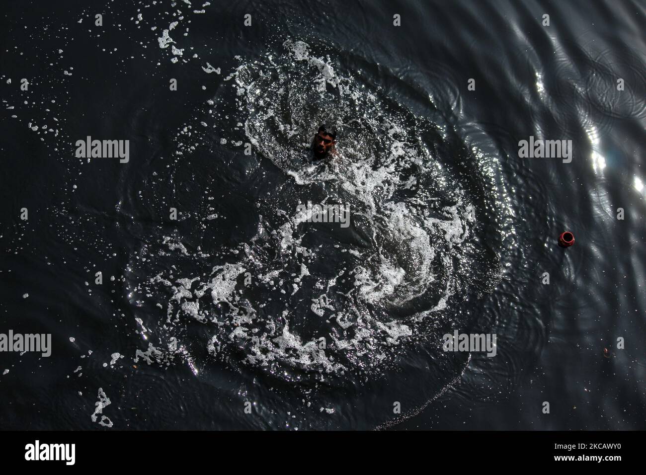 A man looks for valuables in the polluted river Yamuna, in New Delhi ...