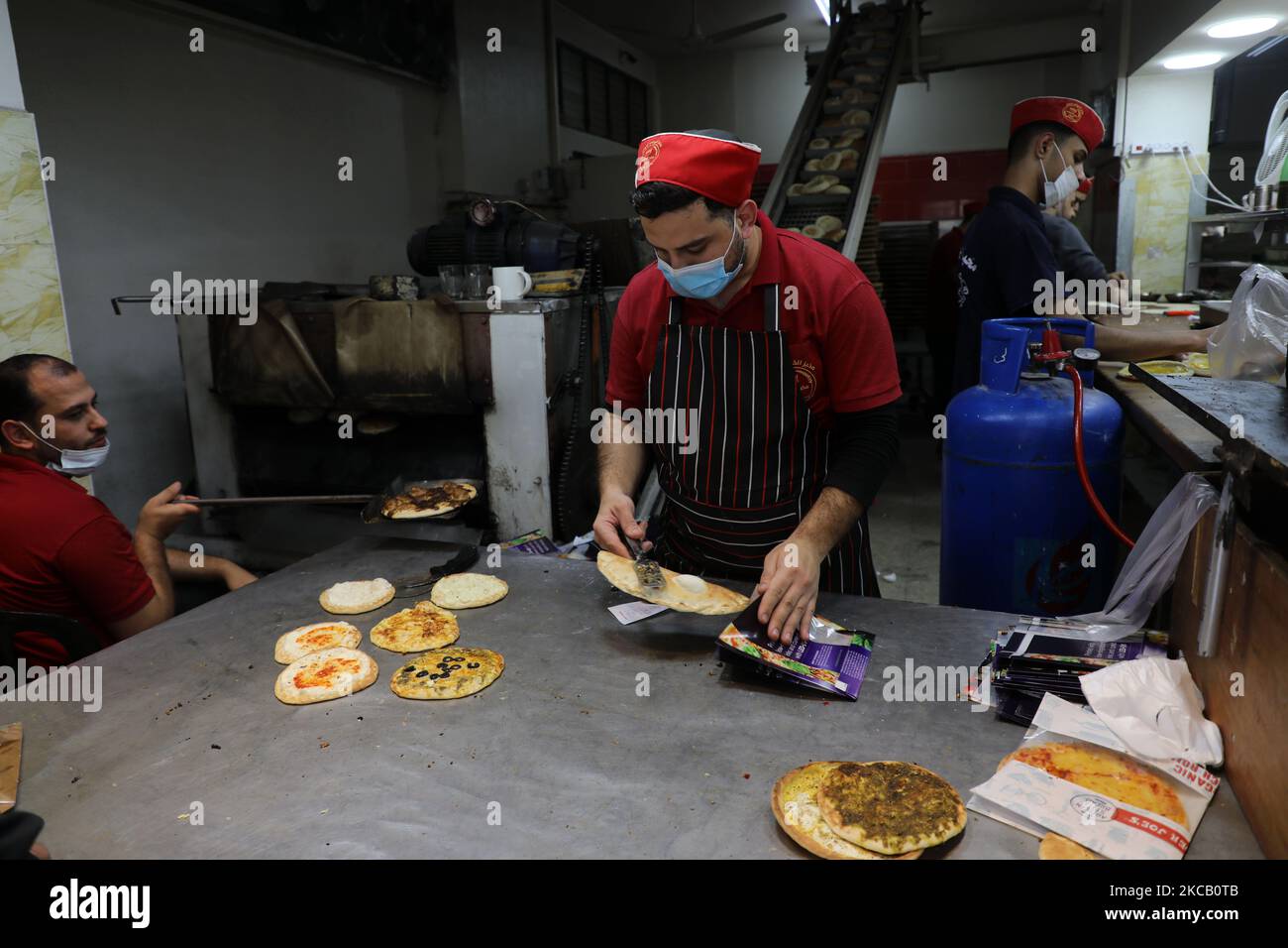 Palestinian bakers bake bread at a bakery in Gaza City on March 16 ...