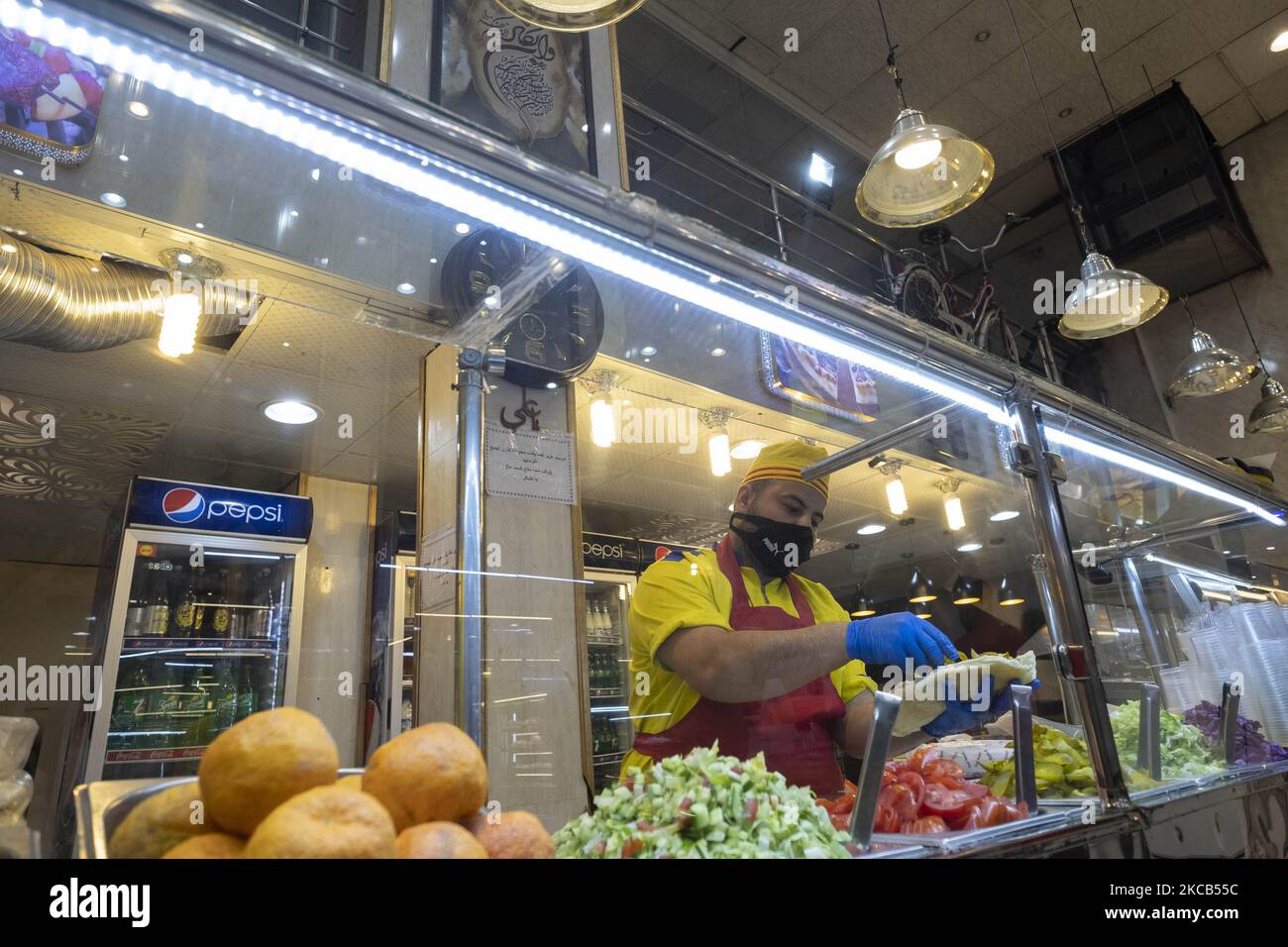 An Iranian-Arab cook prepares a sandwich for a client at a fast-food ...