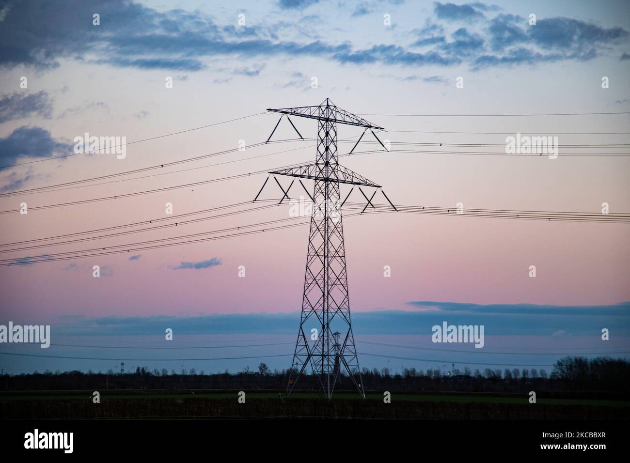 High voltage electricity poles during magic hour. The metal towers as ...