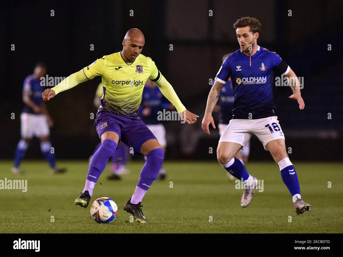 Jake Caprice of Exeter City tussles with Oldham Athletic's Conor ...