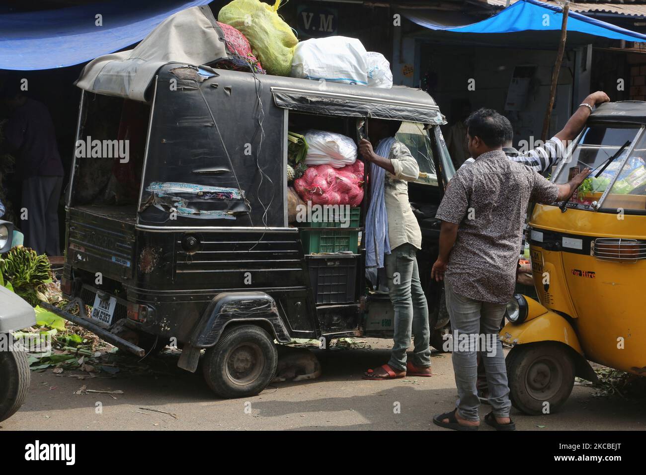 An auto-rickshaw is loaded with fruits and vegetables at the Chalai ...
