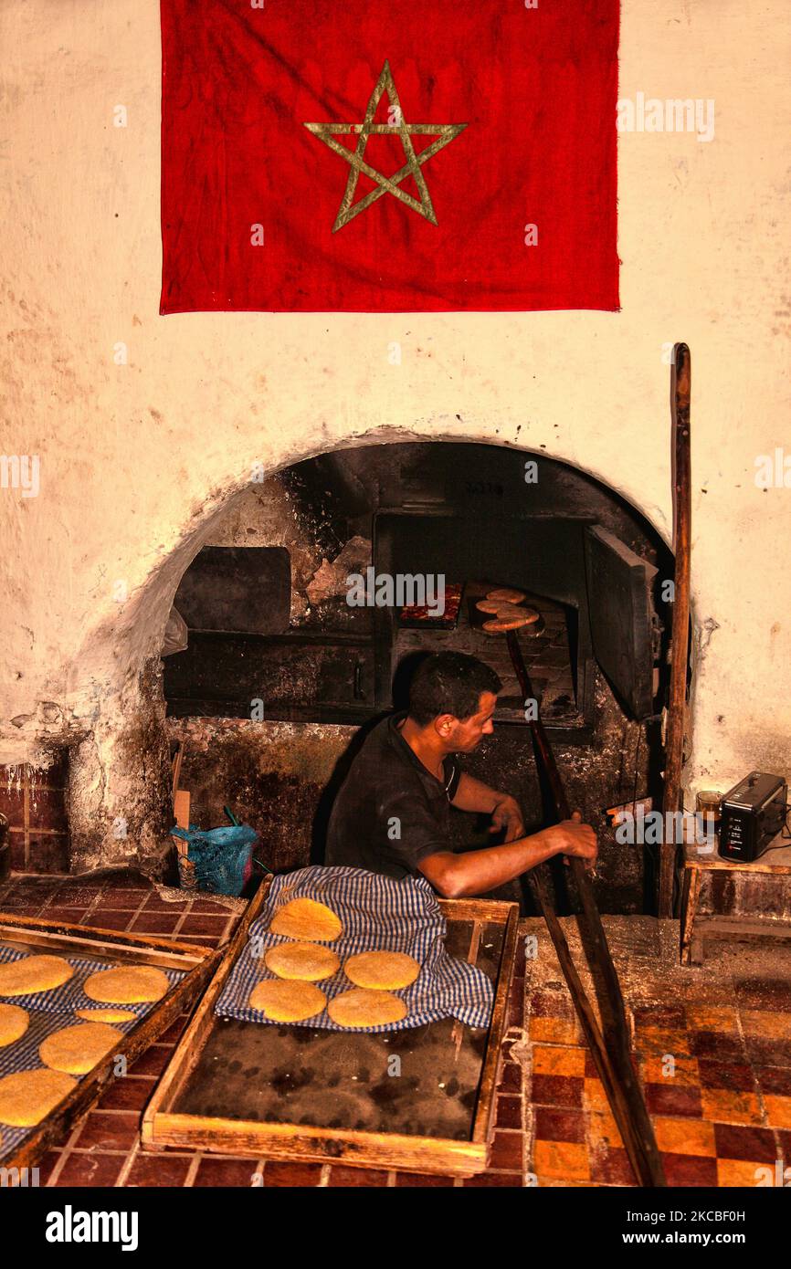 Baker making traditional flatbread at a bakery in the medina (old city ...