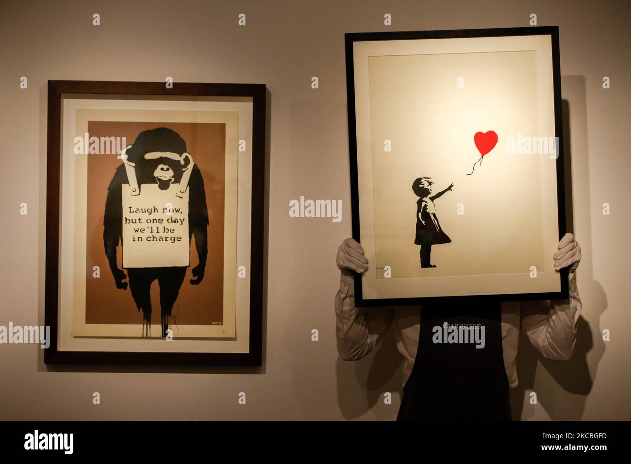 An art handler poses holding 'Girl with Balloon', by British artist ...