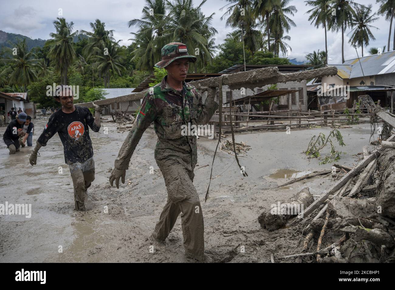 Soldiers and volunteers clean up the remaining mud that hit a house in ...