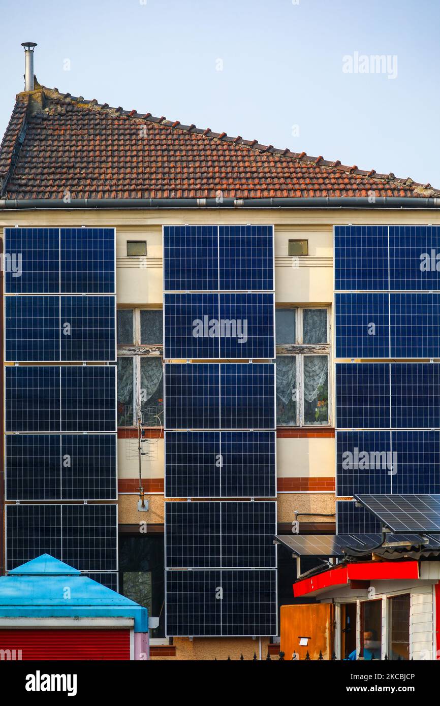 A number of solar collector panels are attached to the front wall of an ...