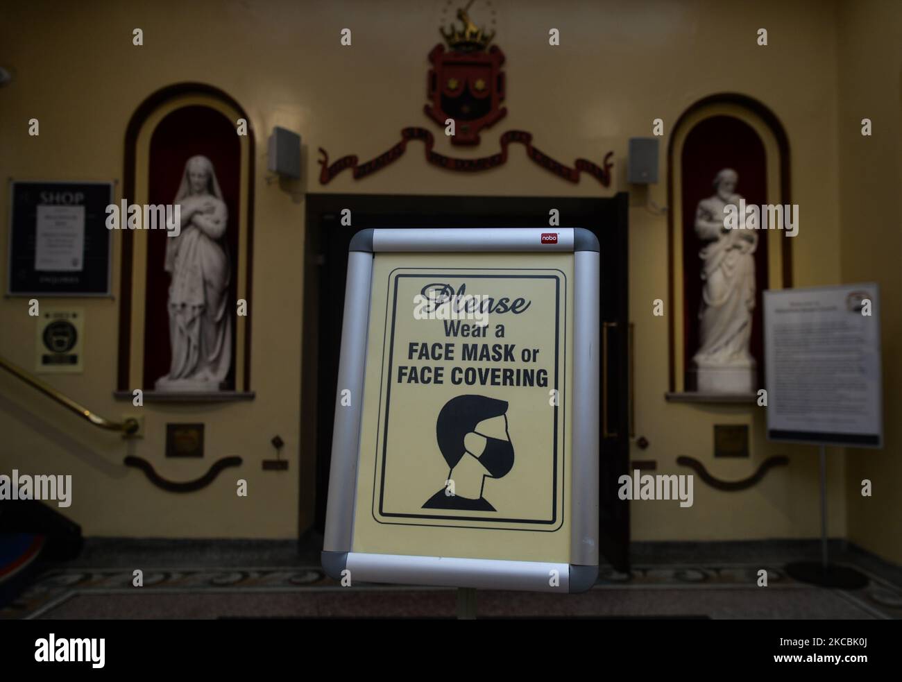 A sign 'Please Wear A Face Mask' at the entrance to Carmelite Church in ...