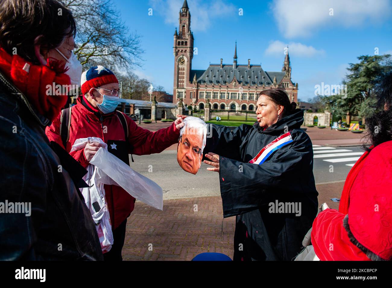 A woman is getting dressing with balck clothes and a Piñera´s face mask ...